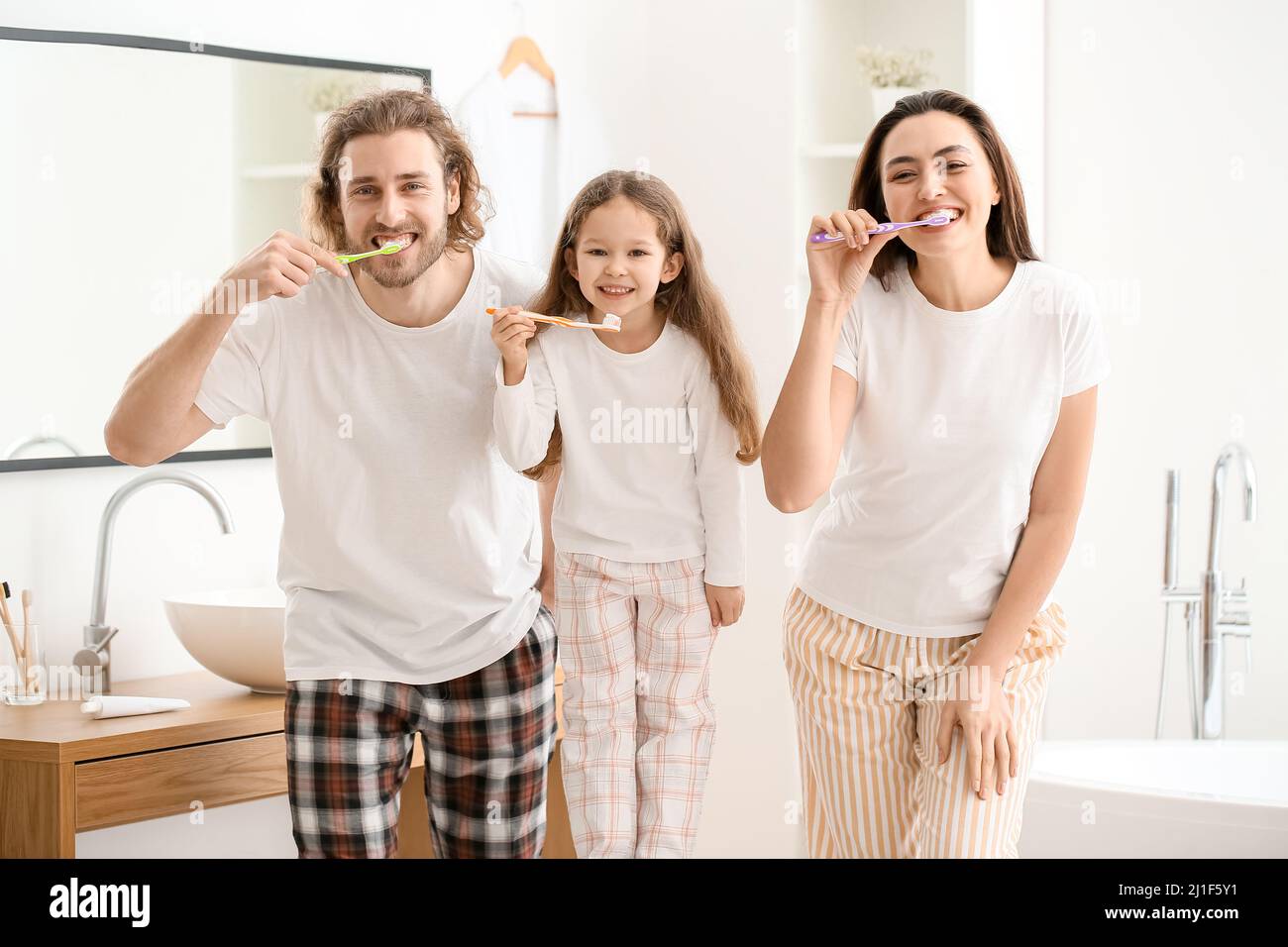 Happy family brushing teeth in bathroom Stock Photo - Alamy
