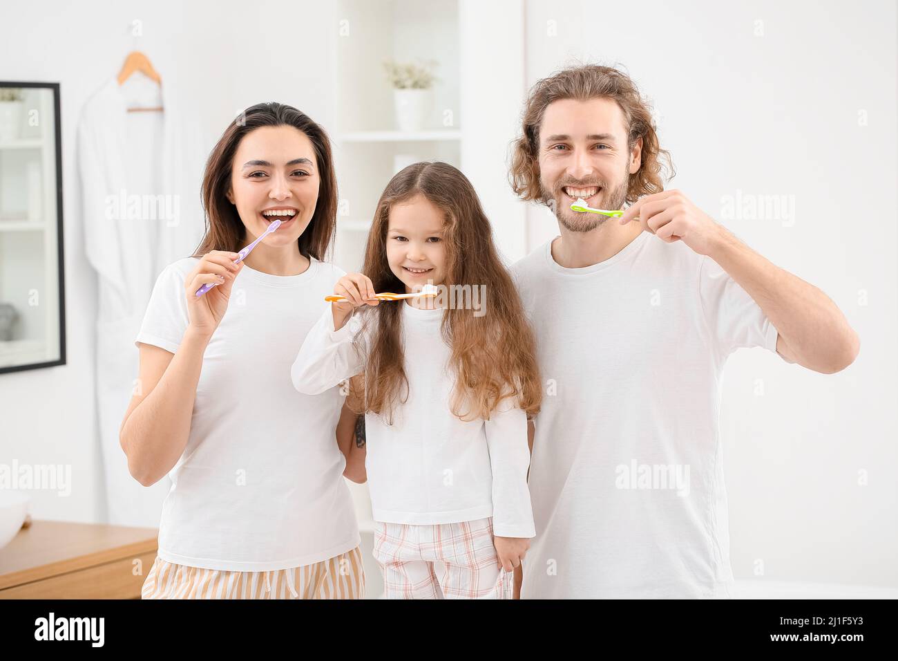 Happy family brushing teeth in bathroom Stock Photo - Alamy