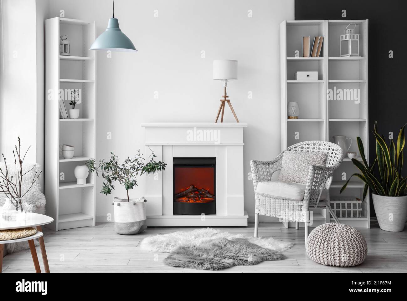 Interior of light room with fireplace and shelf units near white wall ...