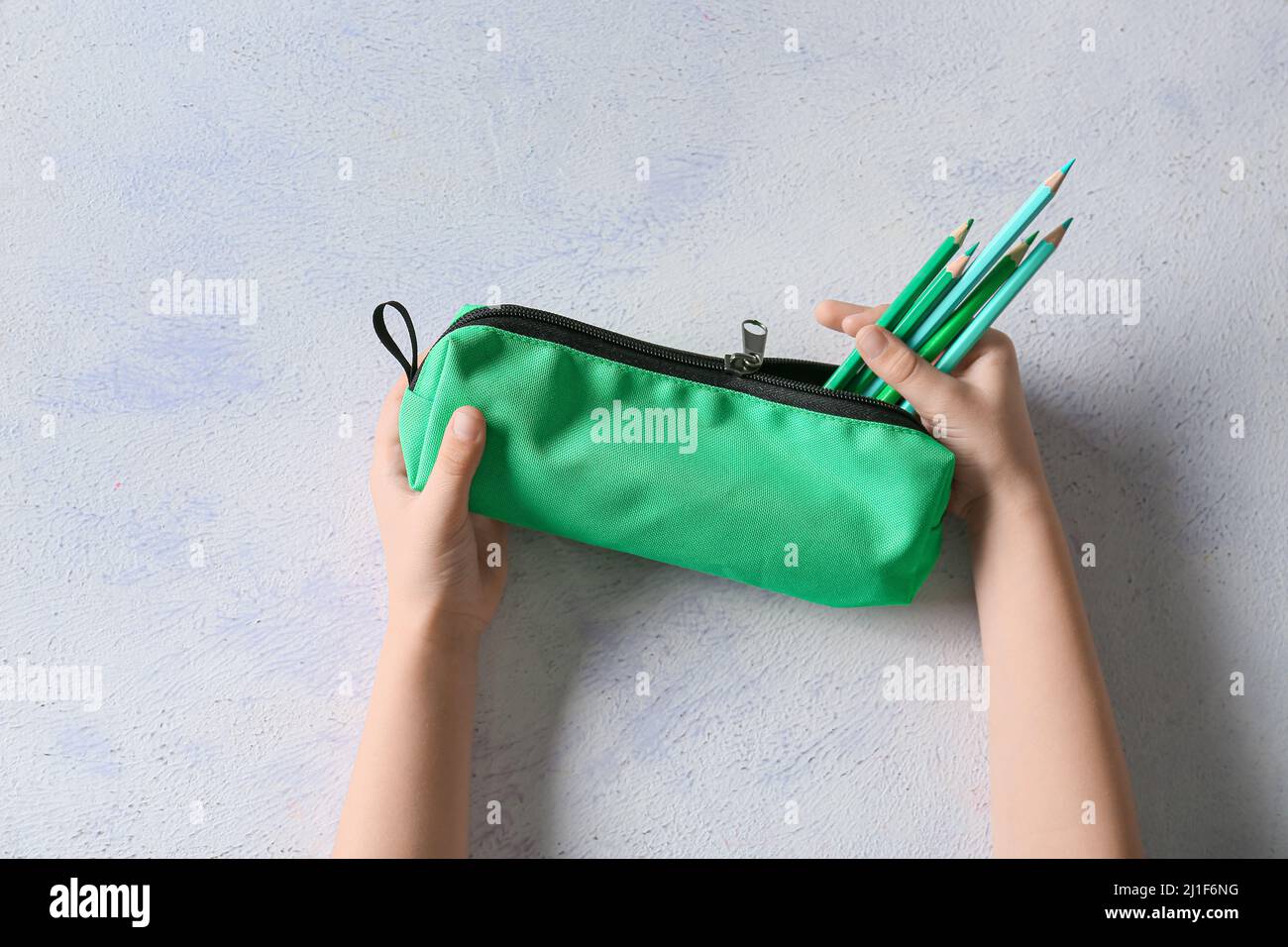 Child's hands with color pencils and case on light background Stock ...