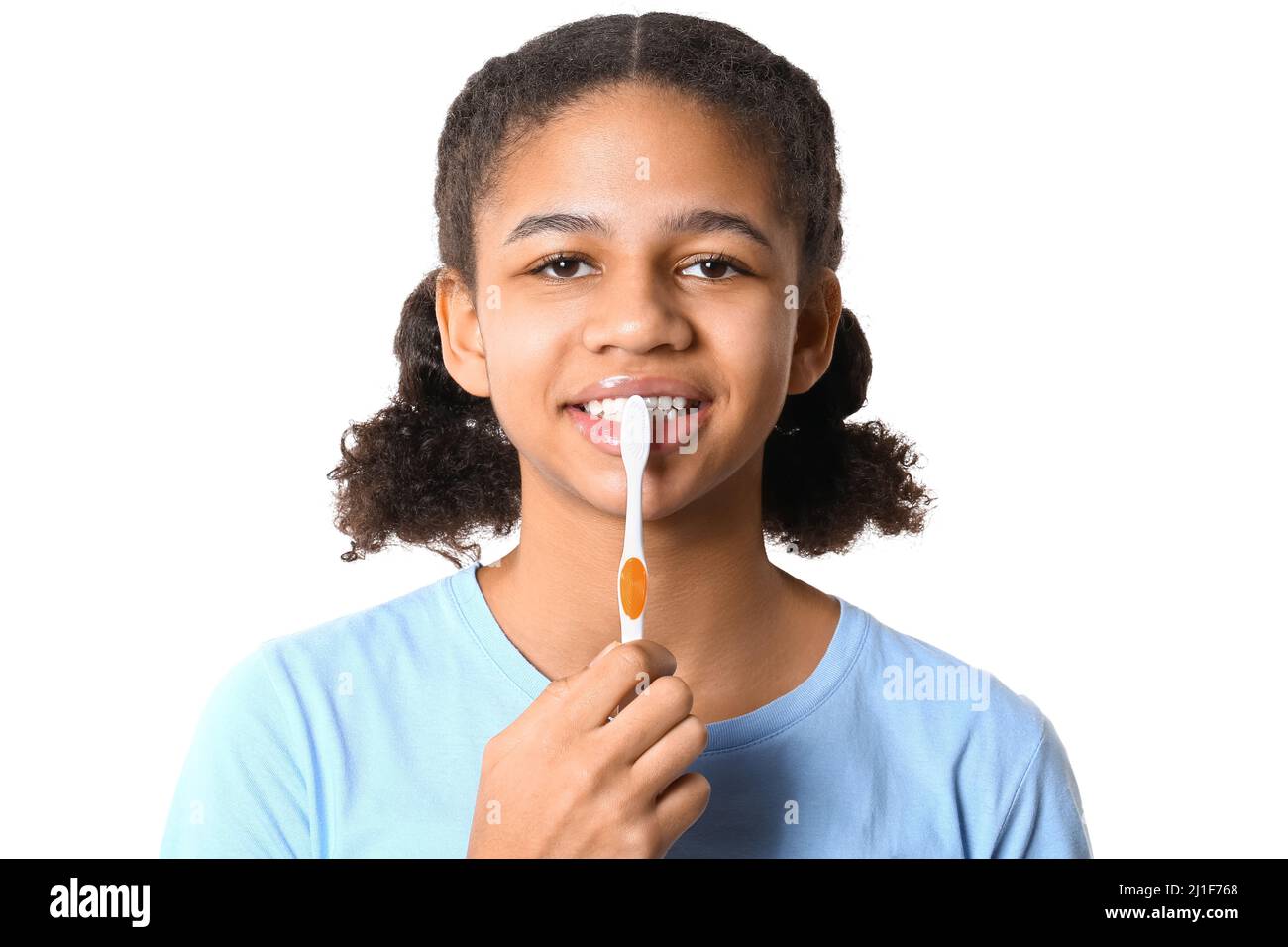 African-American teenage girl brushing teeth on white background Stock ...