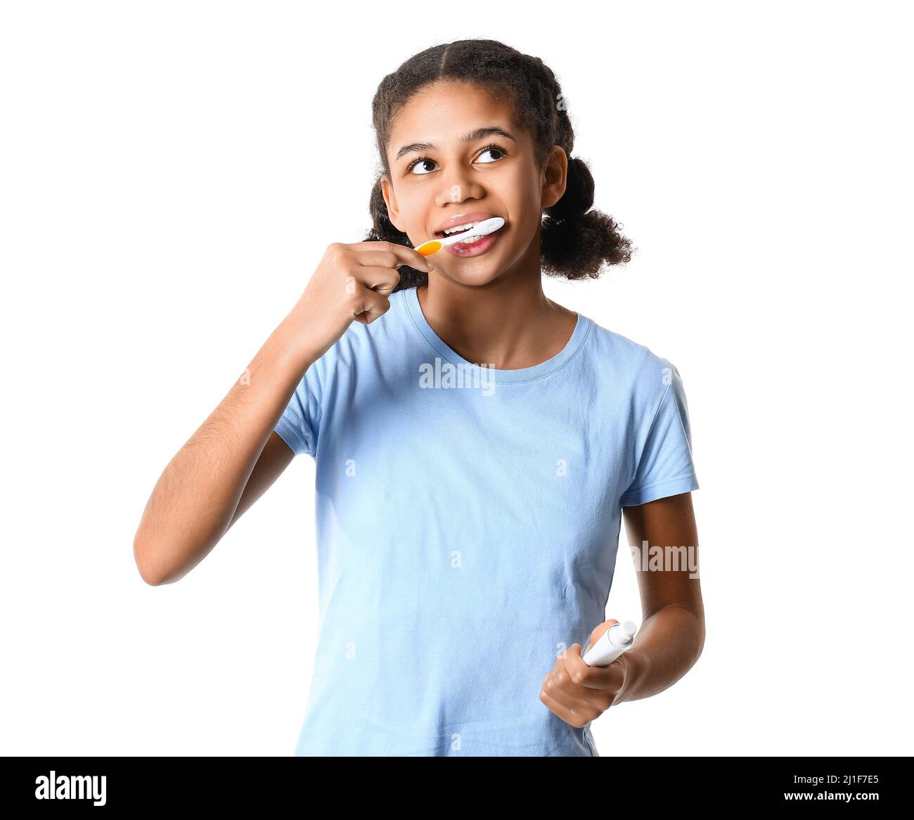 African-American teenage girl with toothpaste brushing teeth on white ...