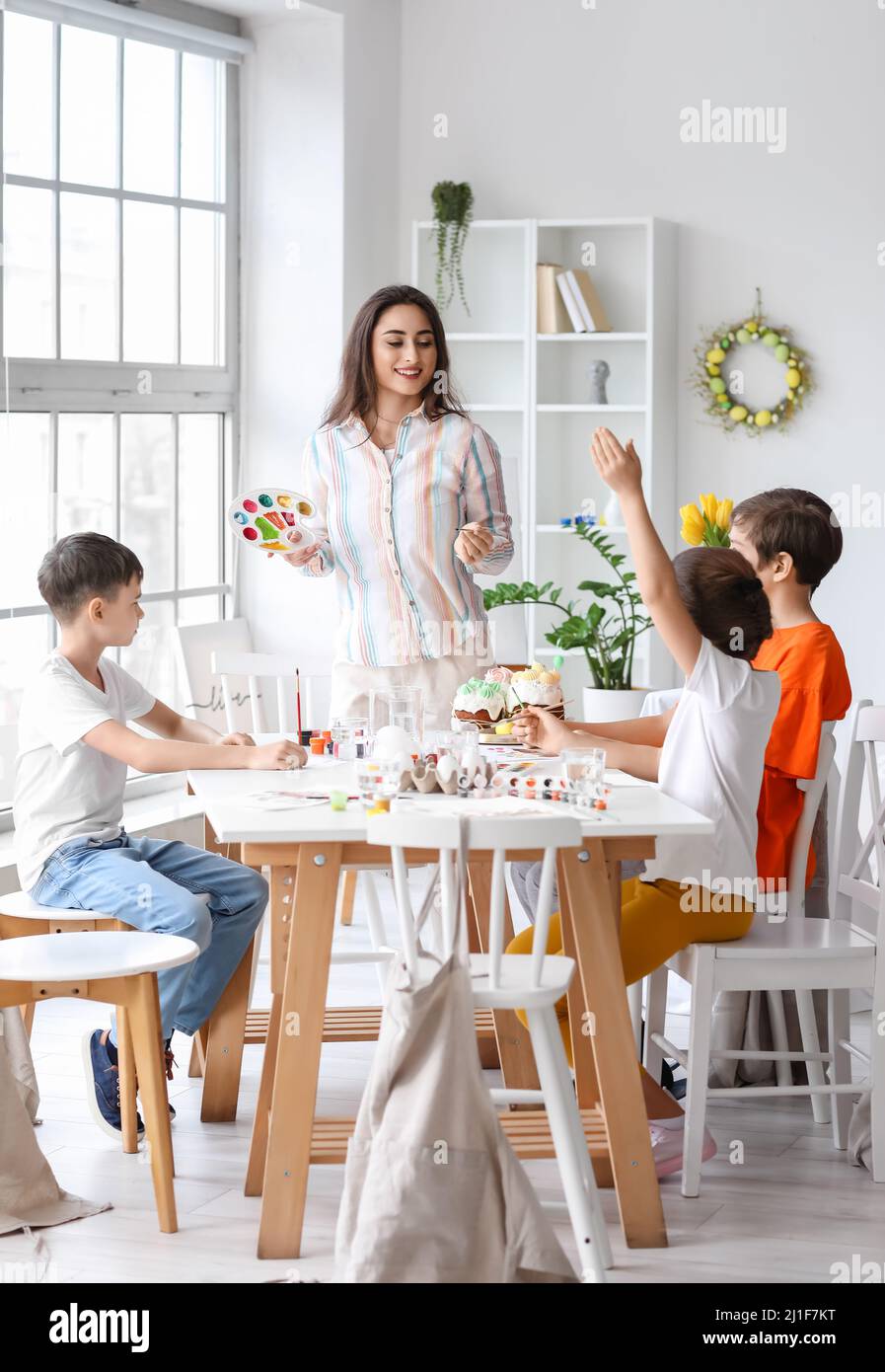 Cute children painting during master-class in art on Easter eve Stock ...