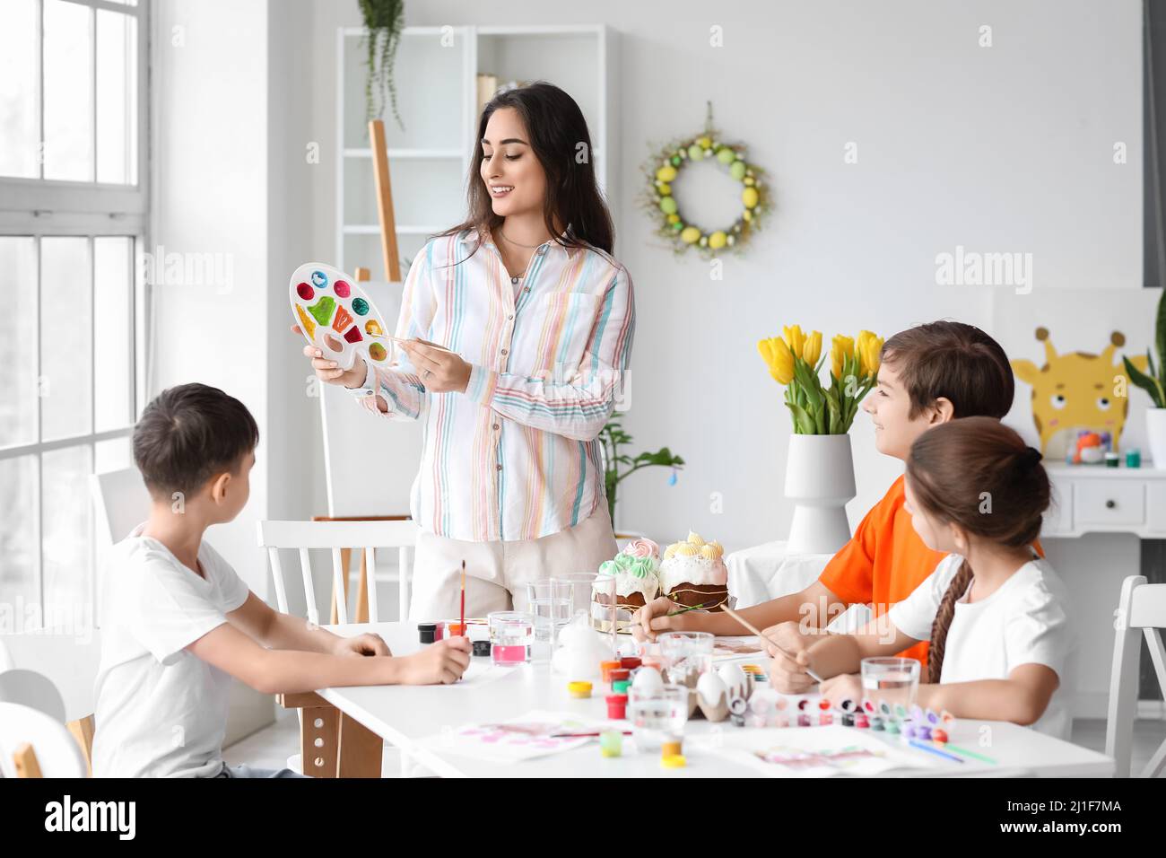 Cute children painting during master-class in art on Easter eve Stock ...