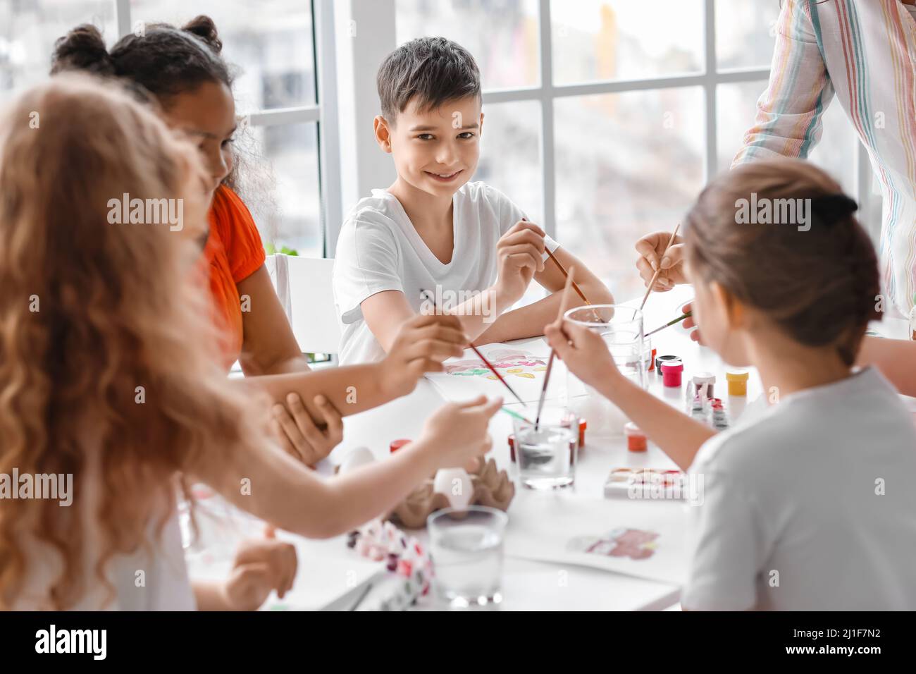 Cute children painting during master-class in art on Easter eve Stock ...