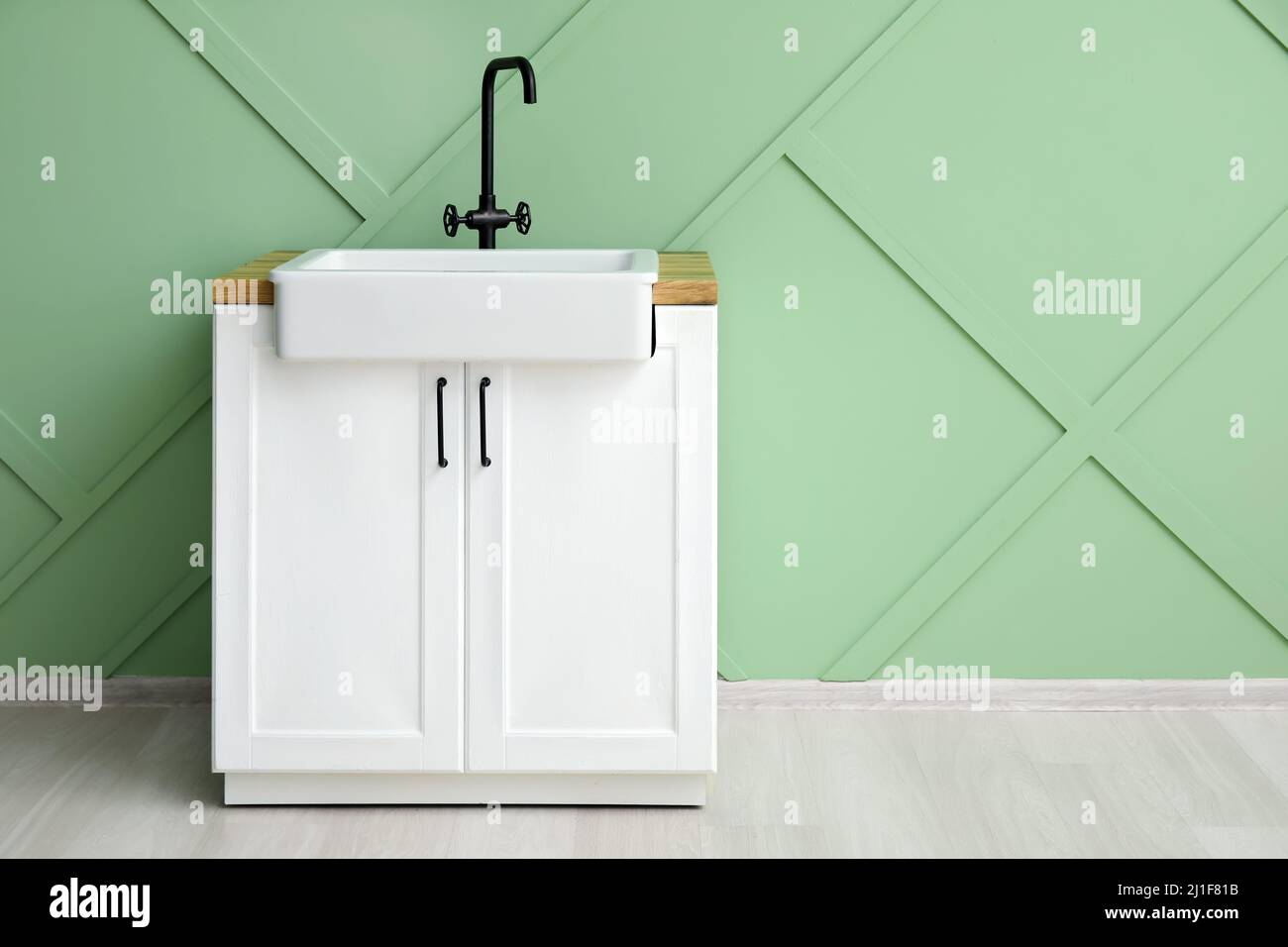 White counter with ceramic sink near green wall Stock Photo - Alamy