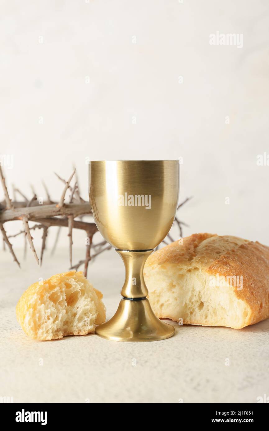 Cup of wine with bread and crown of thorns on light background Stock ...