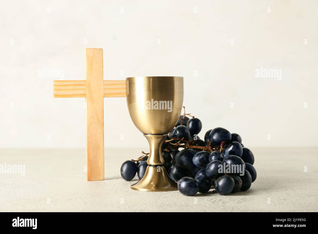 Cup of wine with grapes and cross on light background Stock Photo - Alamy