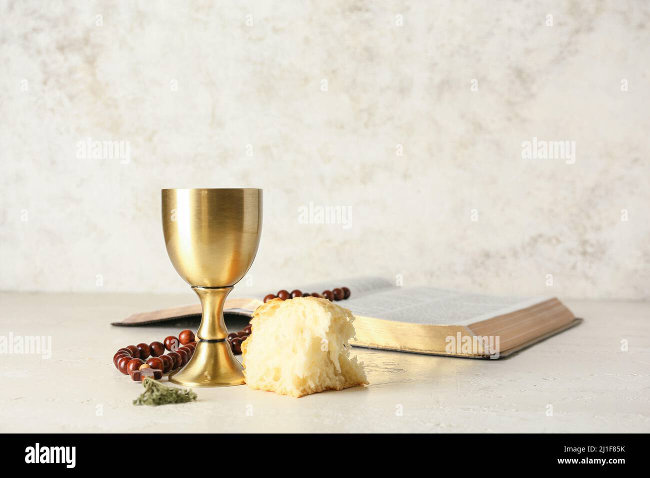 Cup of wine with bread, rosary and Holy Bible on light background Stock ...