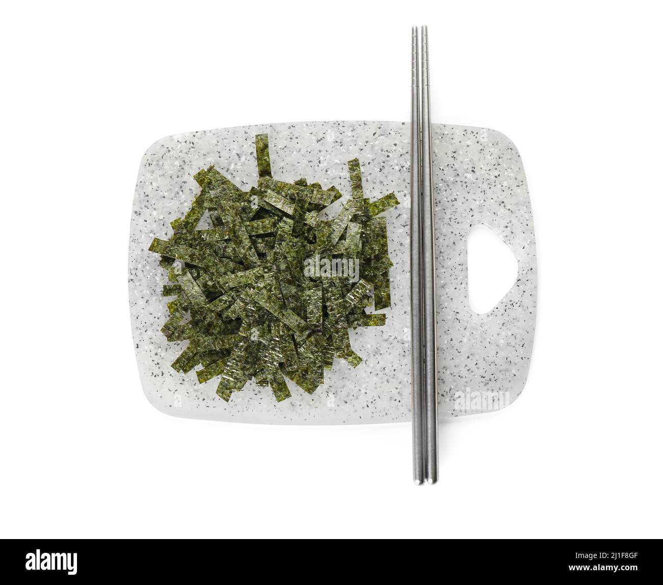 Board with chopped seaweed sheets and chopsticks on white background ...