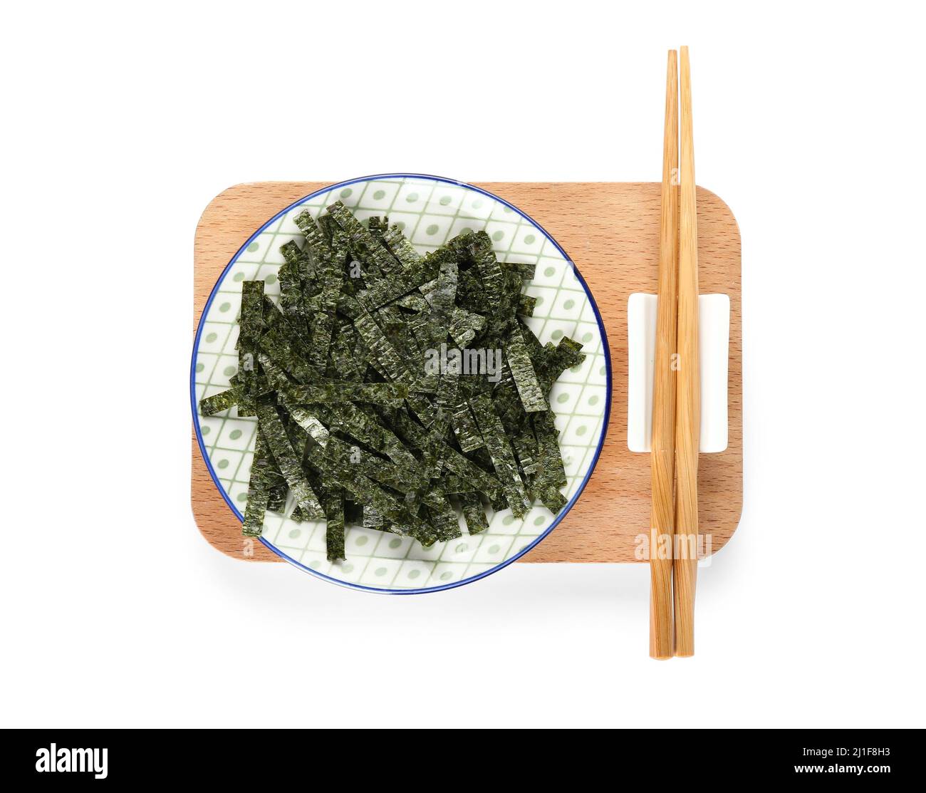 Plate with chopped seaweed sheets and chopsticks on white background ...