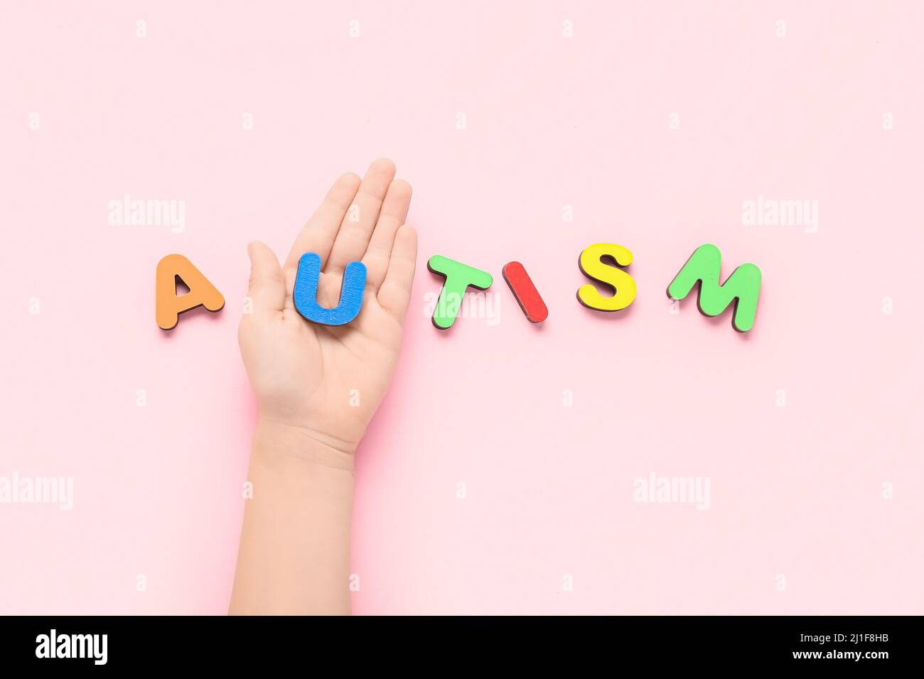 Child with word AUTISM on pink background Stock Photo - Alamy