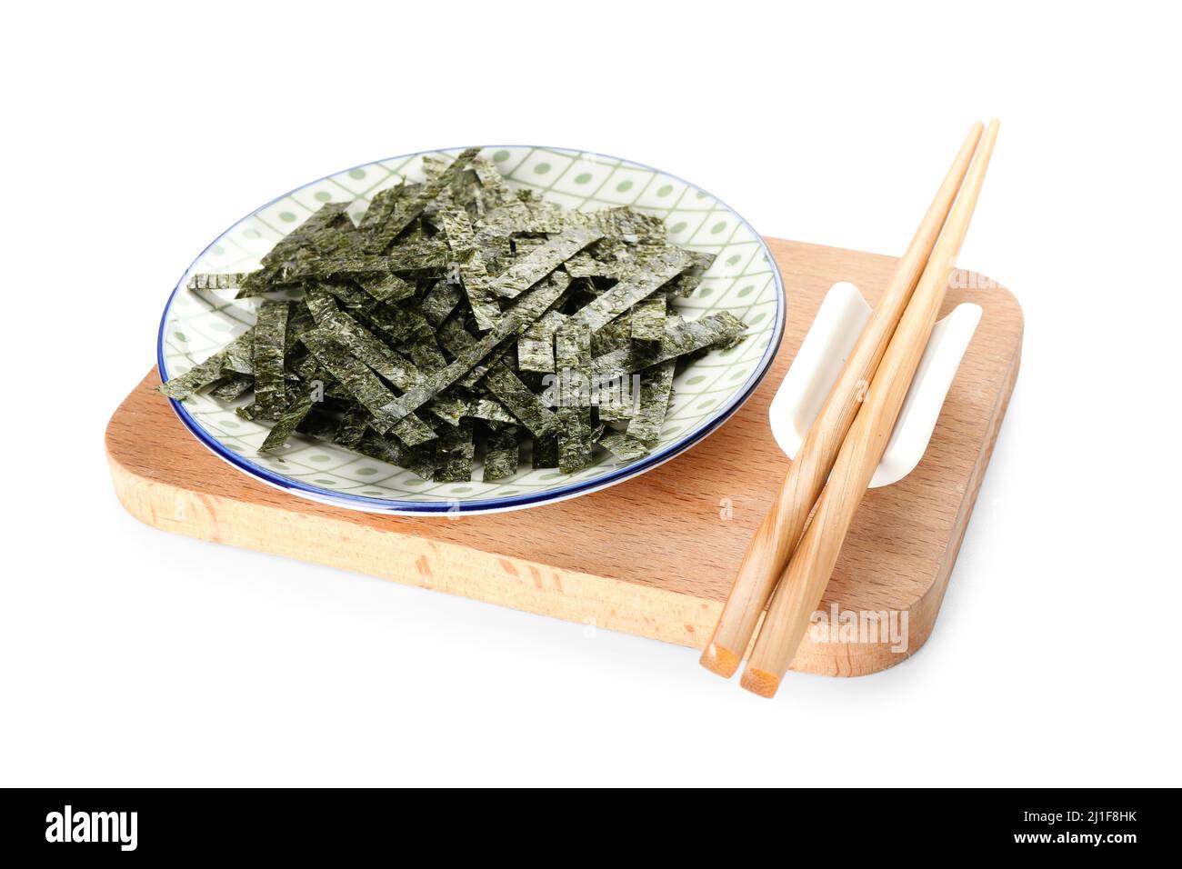 Plate with chopped seaweed sheets and chopsticks on white background ...