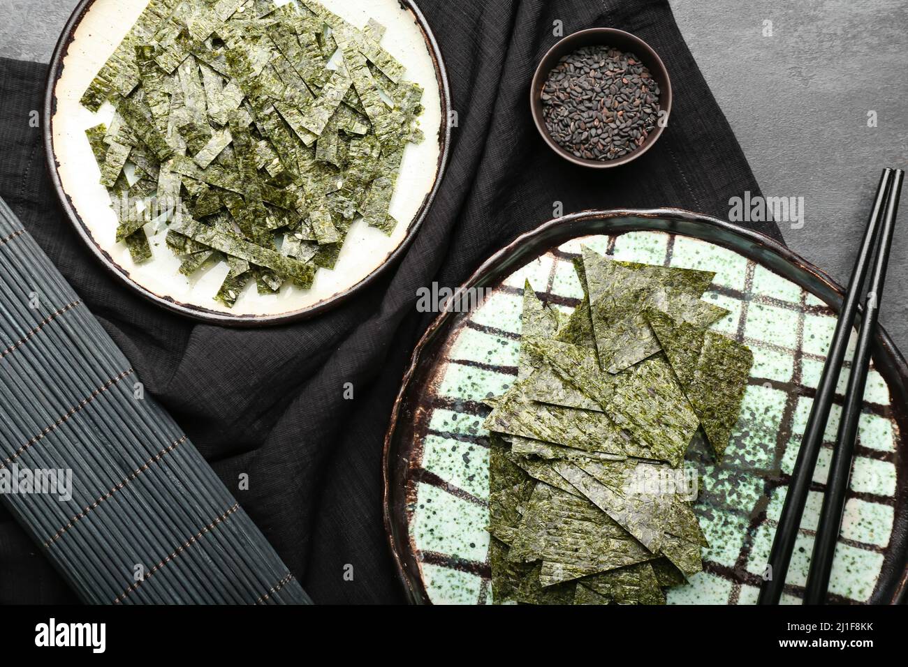 Plates of tasty seaweed sheets on black background Stock Photo - Alamy