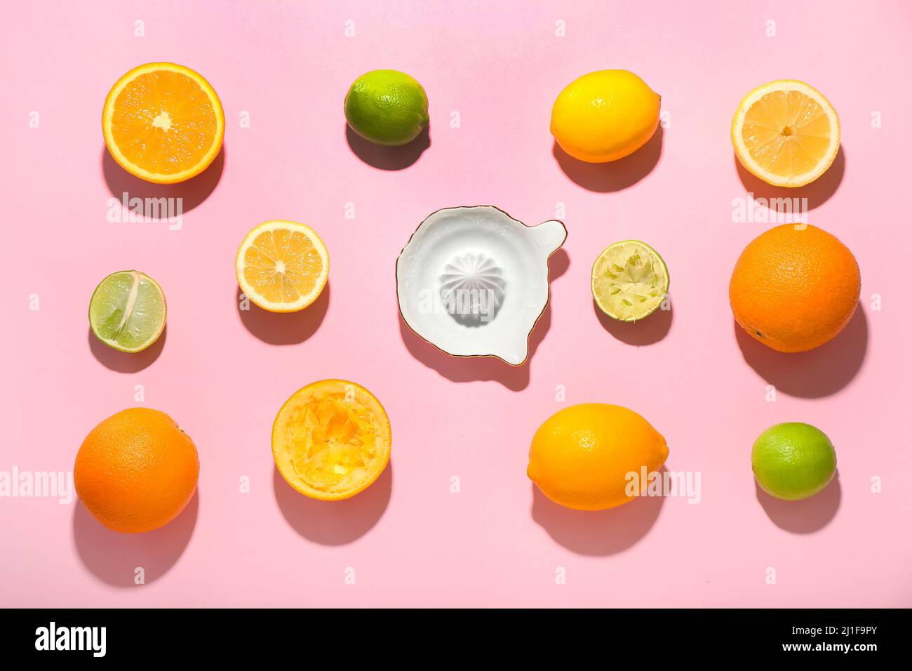 Ceramic juicer and citrus fruits on pink background Stock Photo - Alamy
