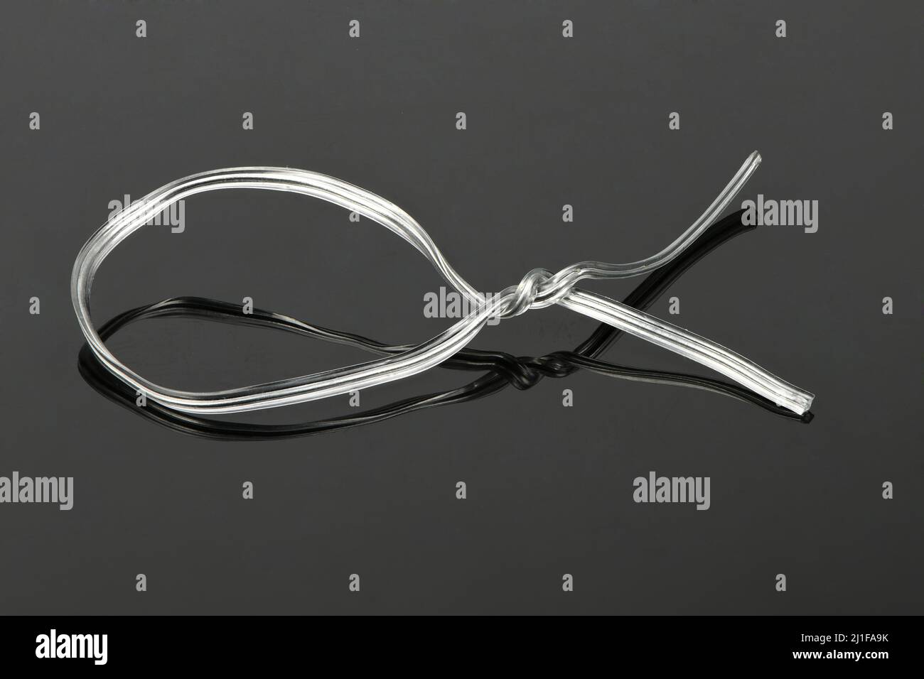 White plastic coated wire tie used for a variety of things on black ...