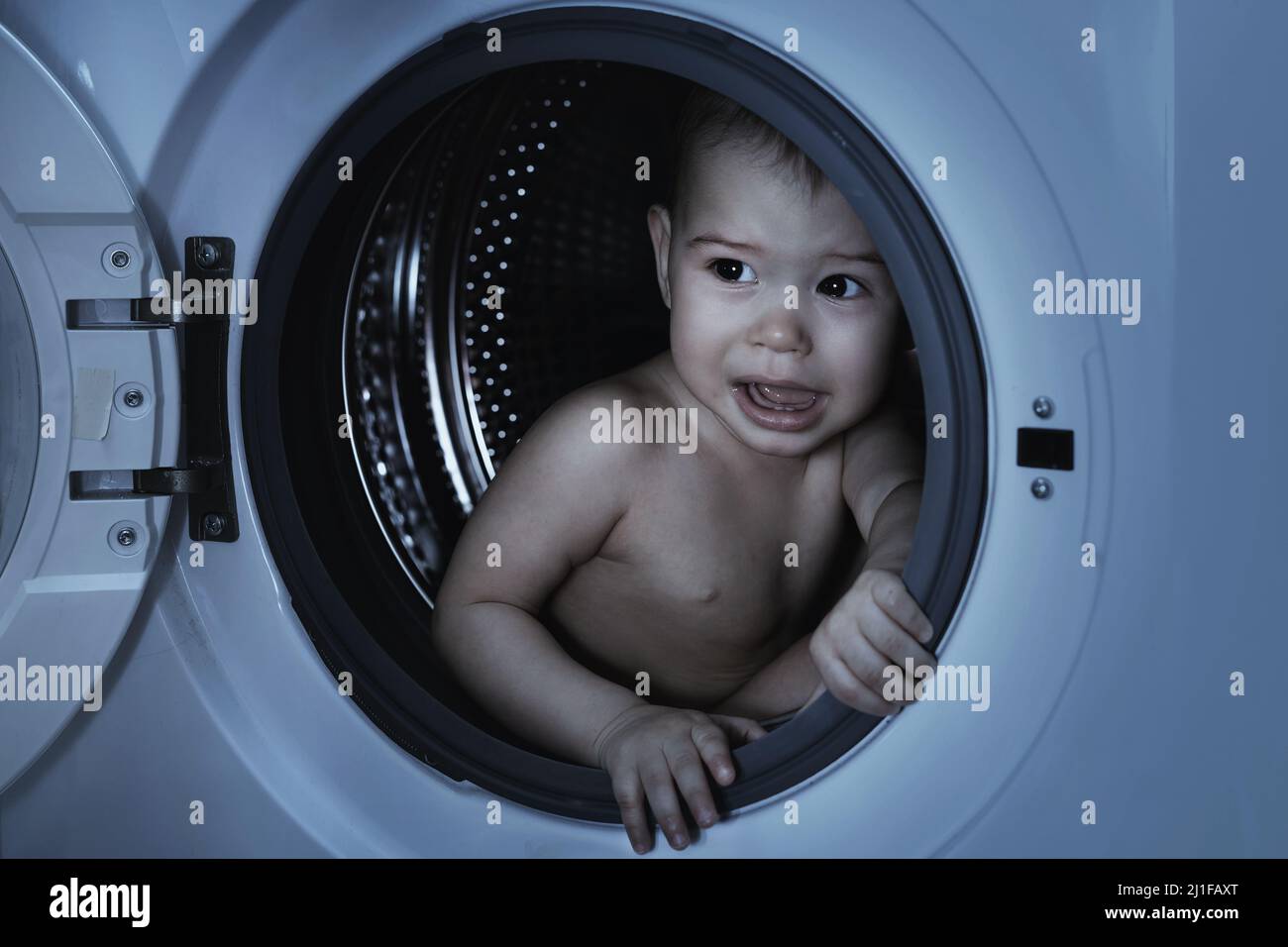 Scared baby boy sitting inside the washing machine Stock Photo - Alamy