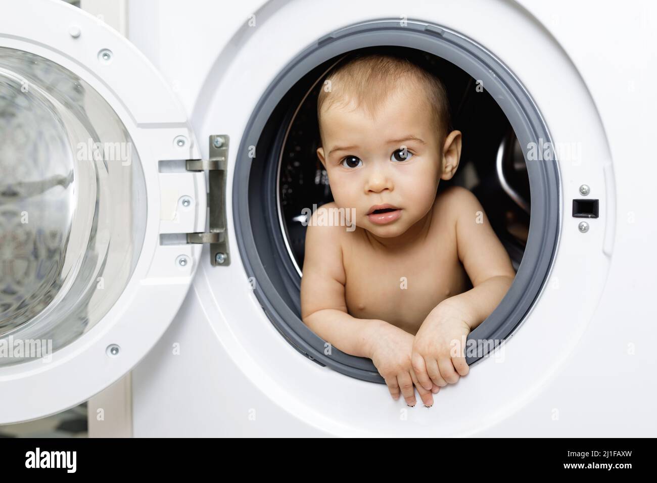 Curious baby boy sitting inside the washing machine Stock Photo - Alamy