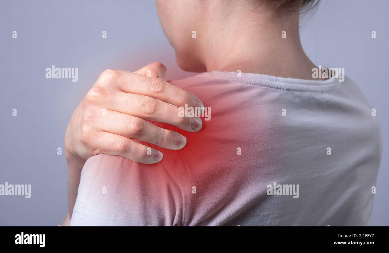 Woman suffering from shoulder pain. Hand holding painful shoulder with ...