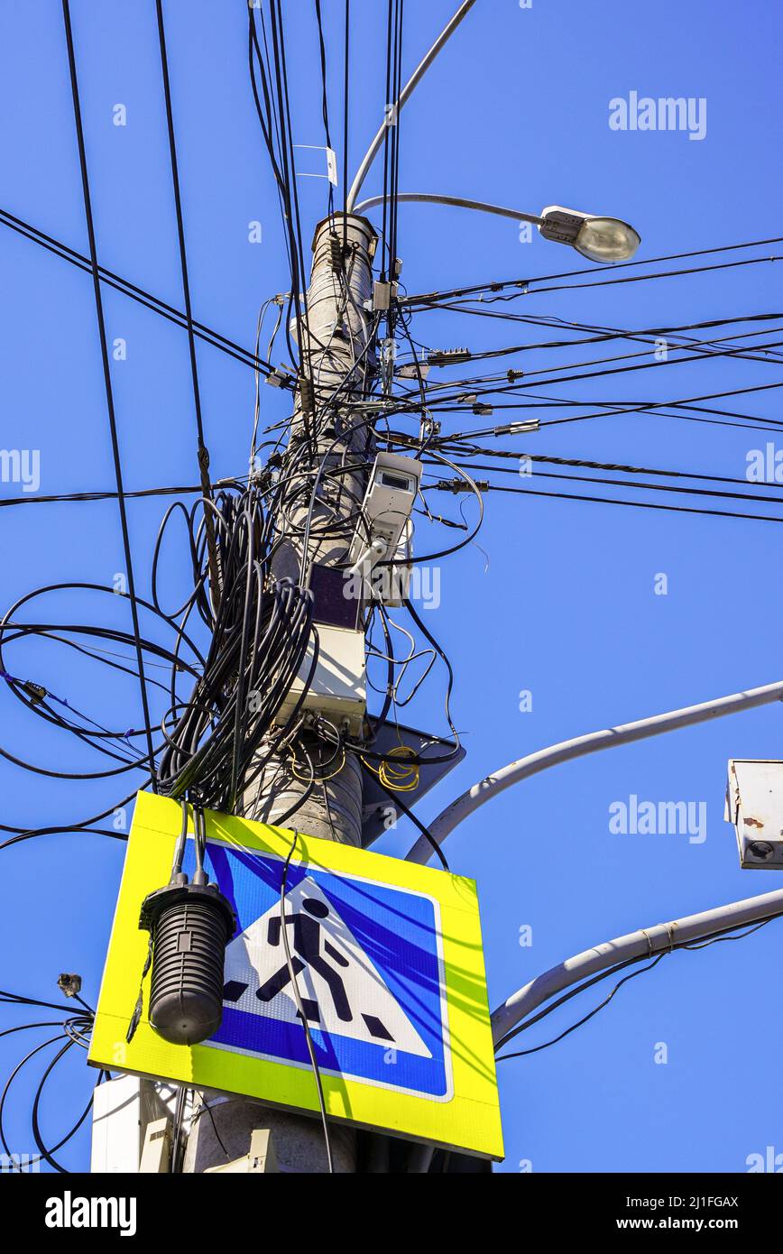 Different electricity, communication cables and road sign are fixed on ...