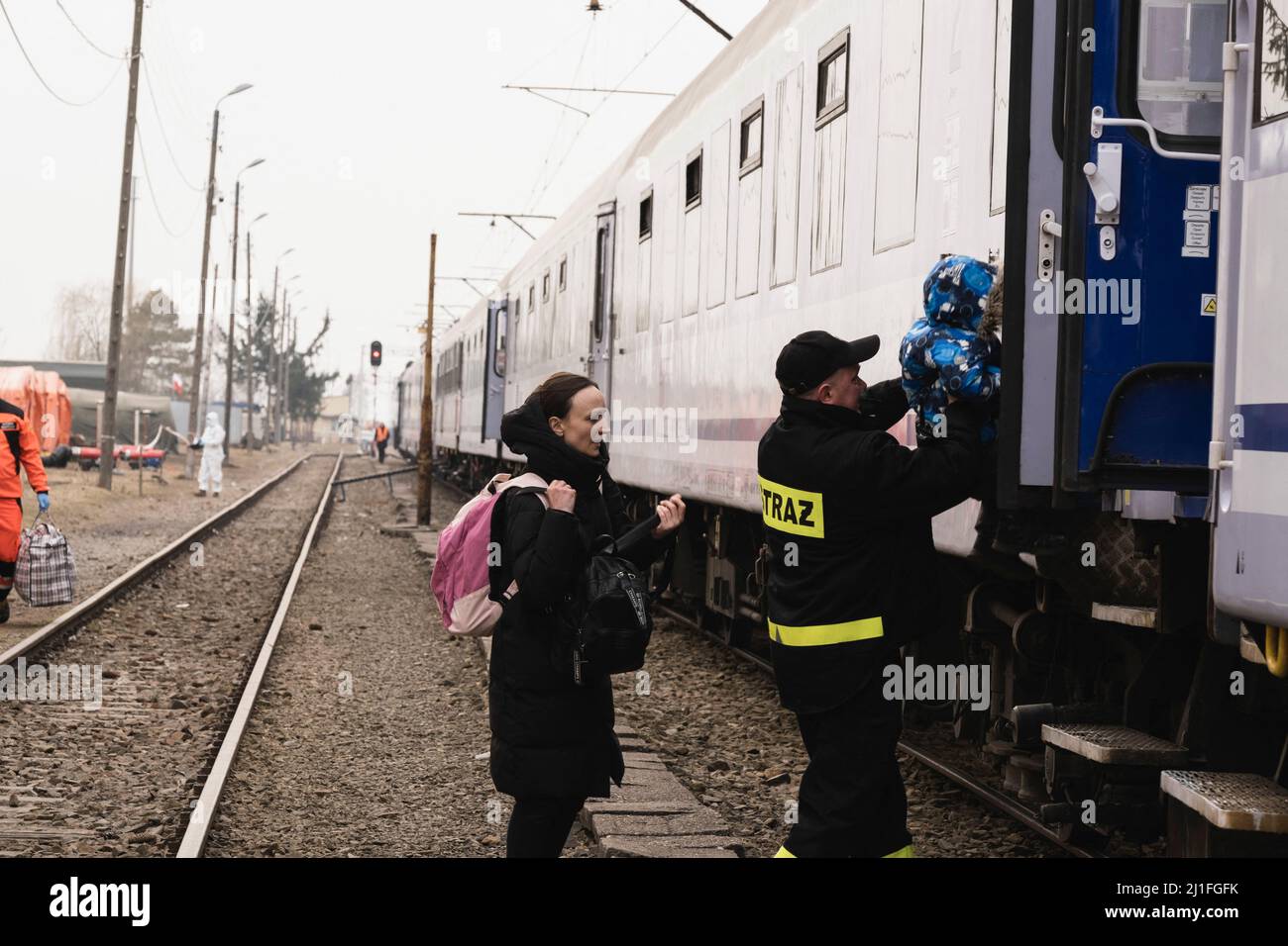 A guard carrying up a child into the train run by the polish red cross ...