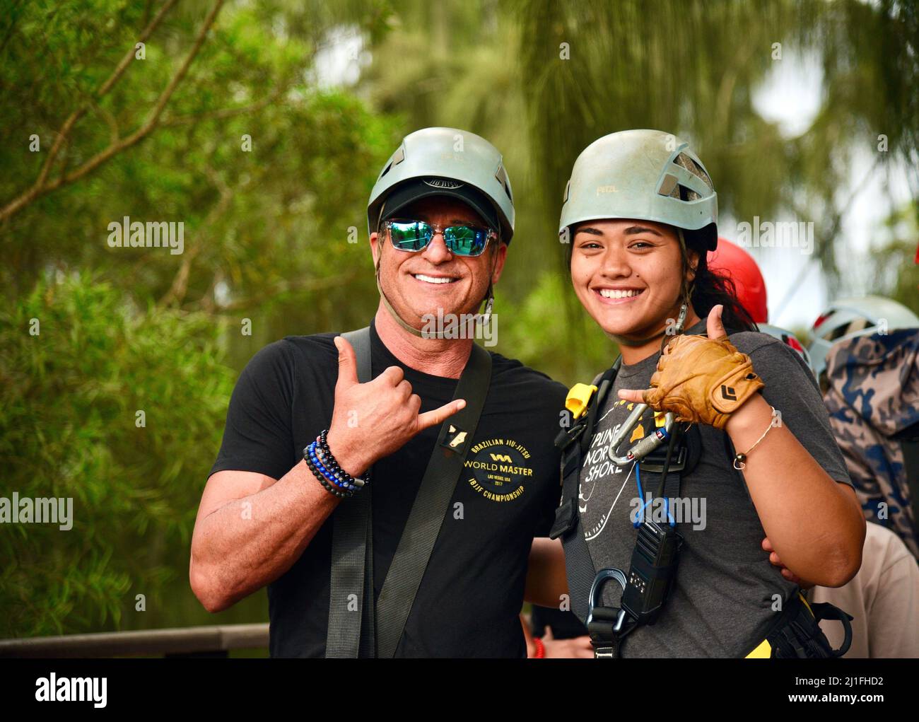 Tour guide and zipline participants smiling and giving shaka hand ...