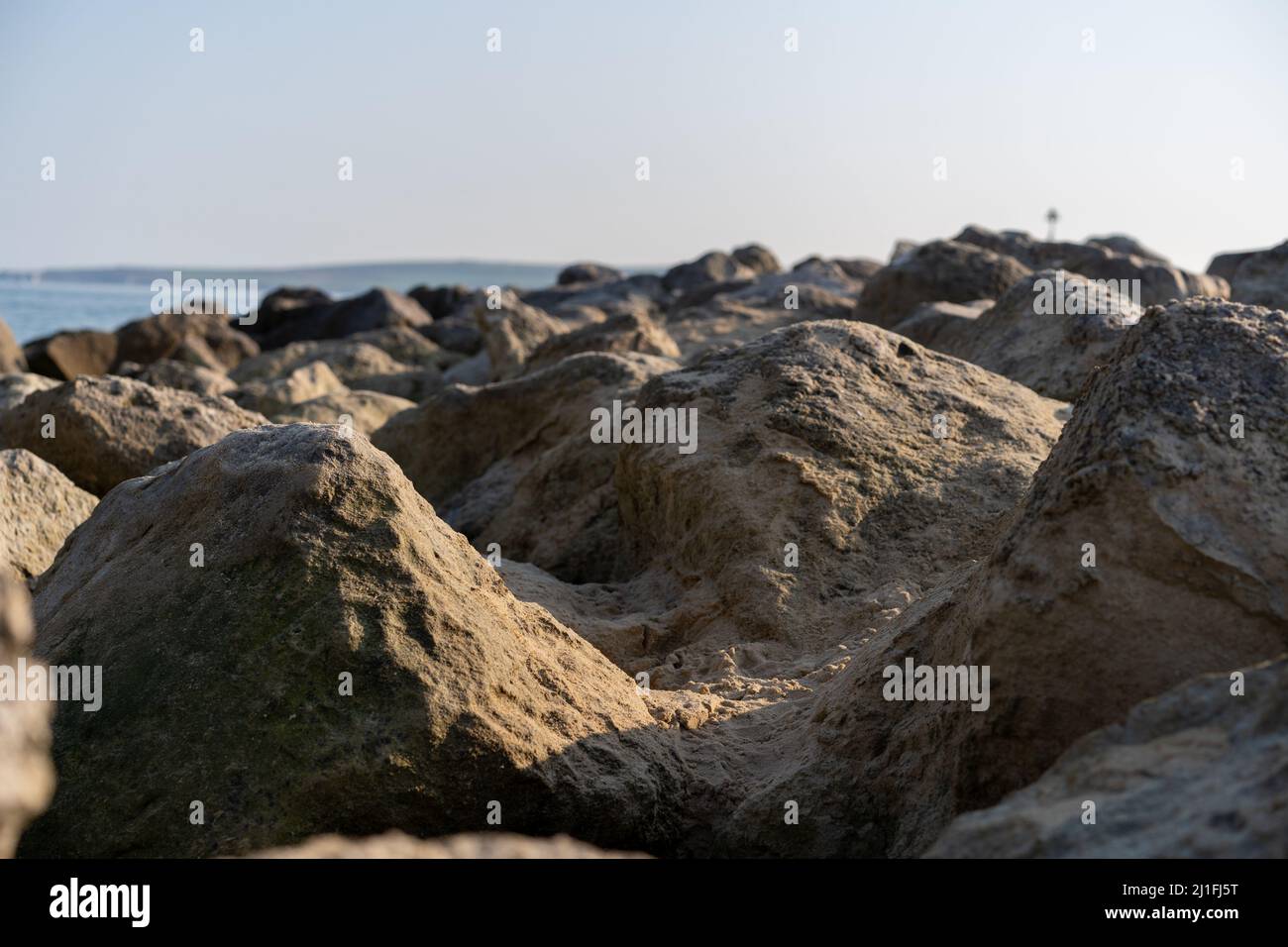 Sand blown over rock groynes Stock Photo - Alamy