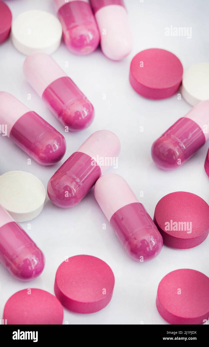 pills and capsules in pink and magenta colors on white background Stock ...