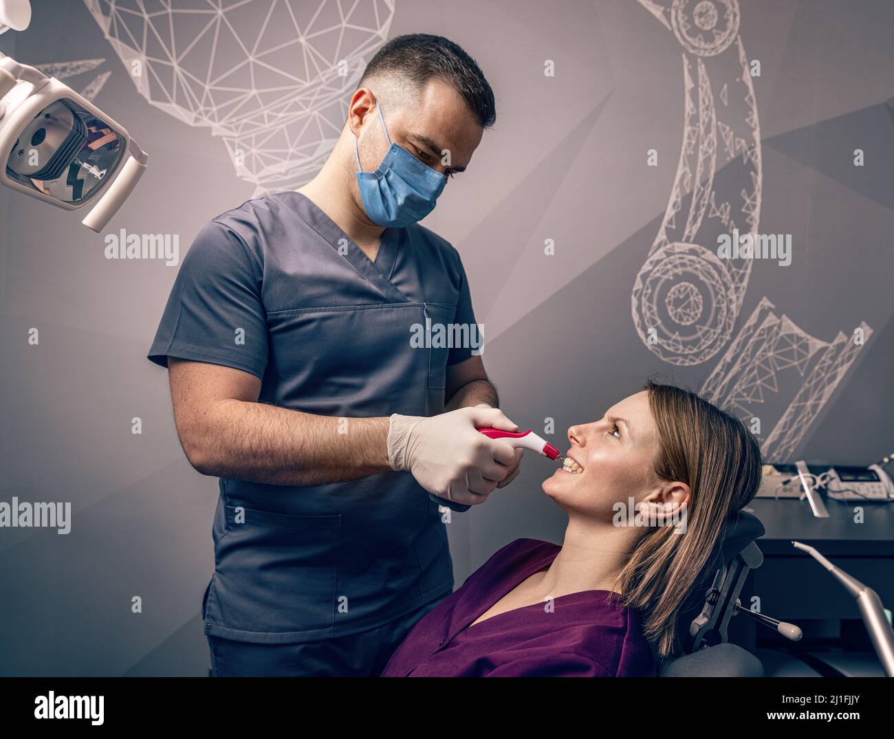 Dentist examine the colour of teeth with digital shade guide teeth ...