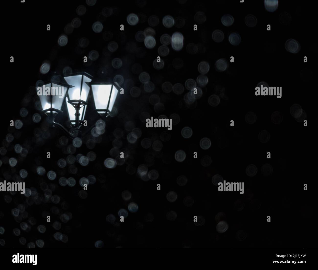 Black and white photo of a flashlight in bokeh. Abstract background of ...