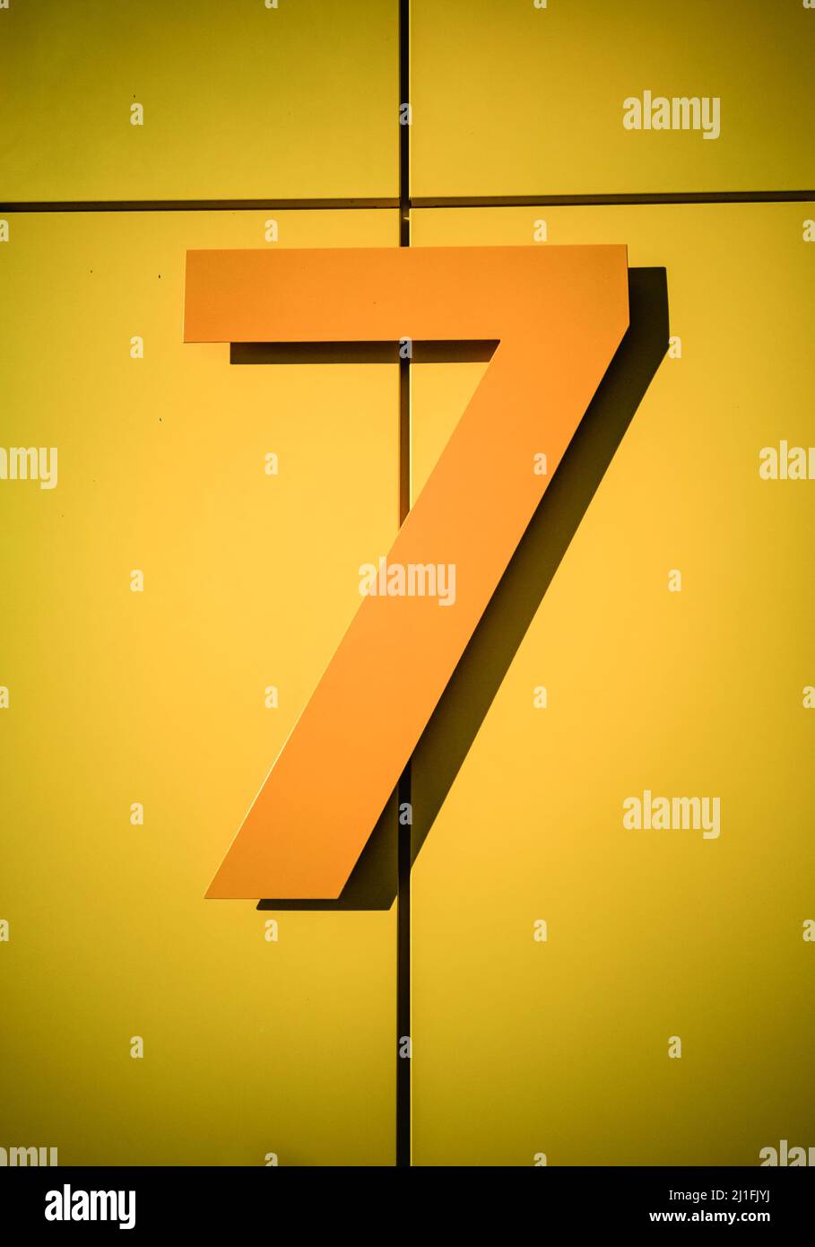 Numeral 7 seven on a yellow background of the facade of the building ...