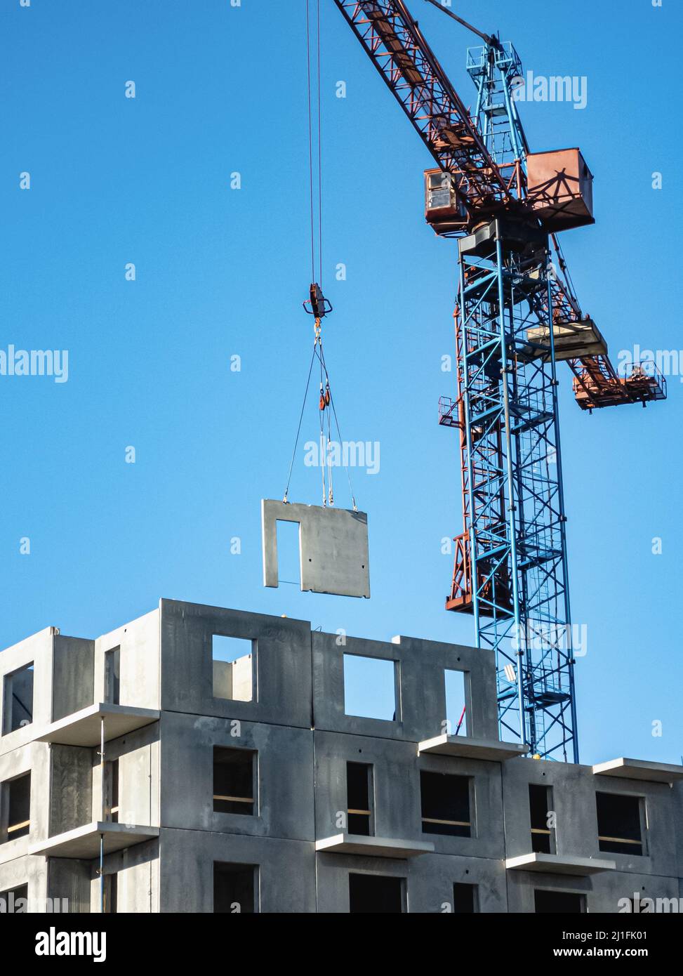 Construction of panel high-rise buildings. Tower crane delivers a ...