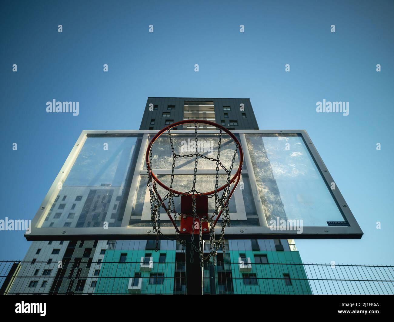 Basketball hoop against a blue sky and high-rise building. Sports ...