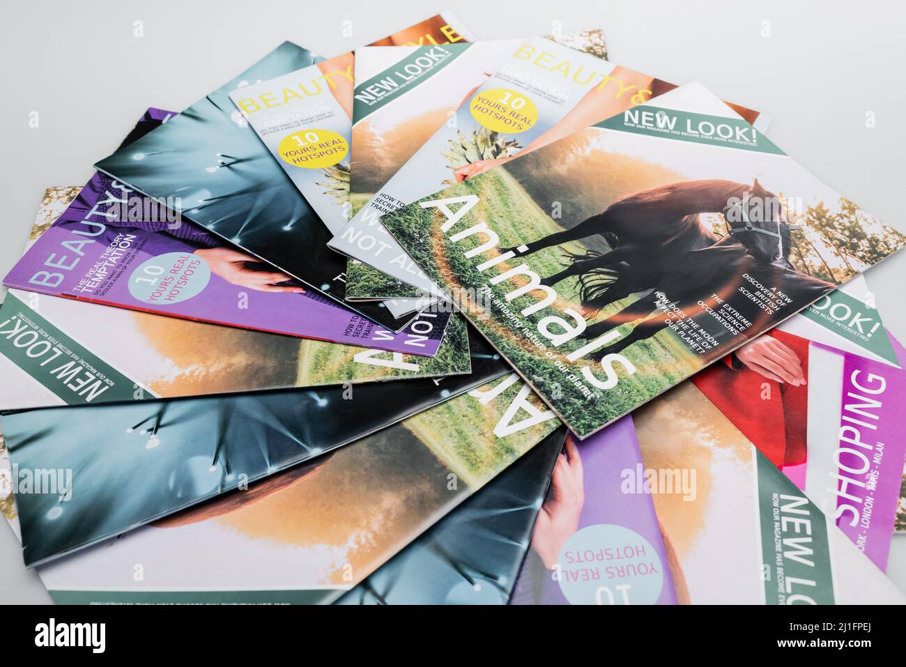 top view of beauty, shopping and naturalistic magazines isolated on ...