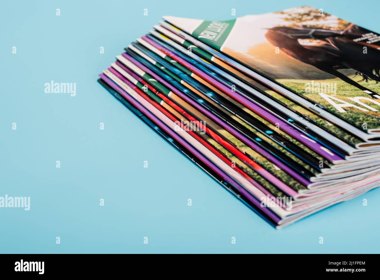 stack of colorful magazines collection isolated on blue Stock Photo - Alamy