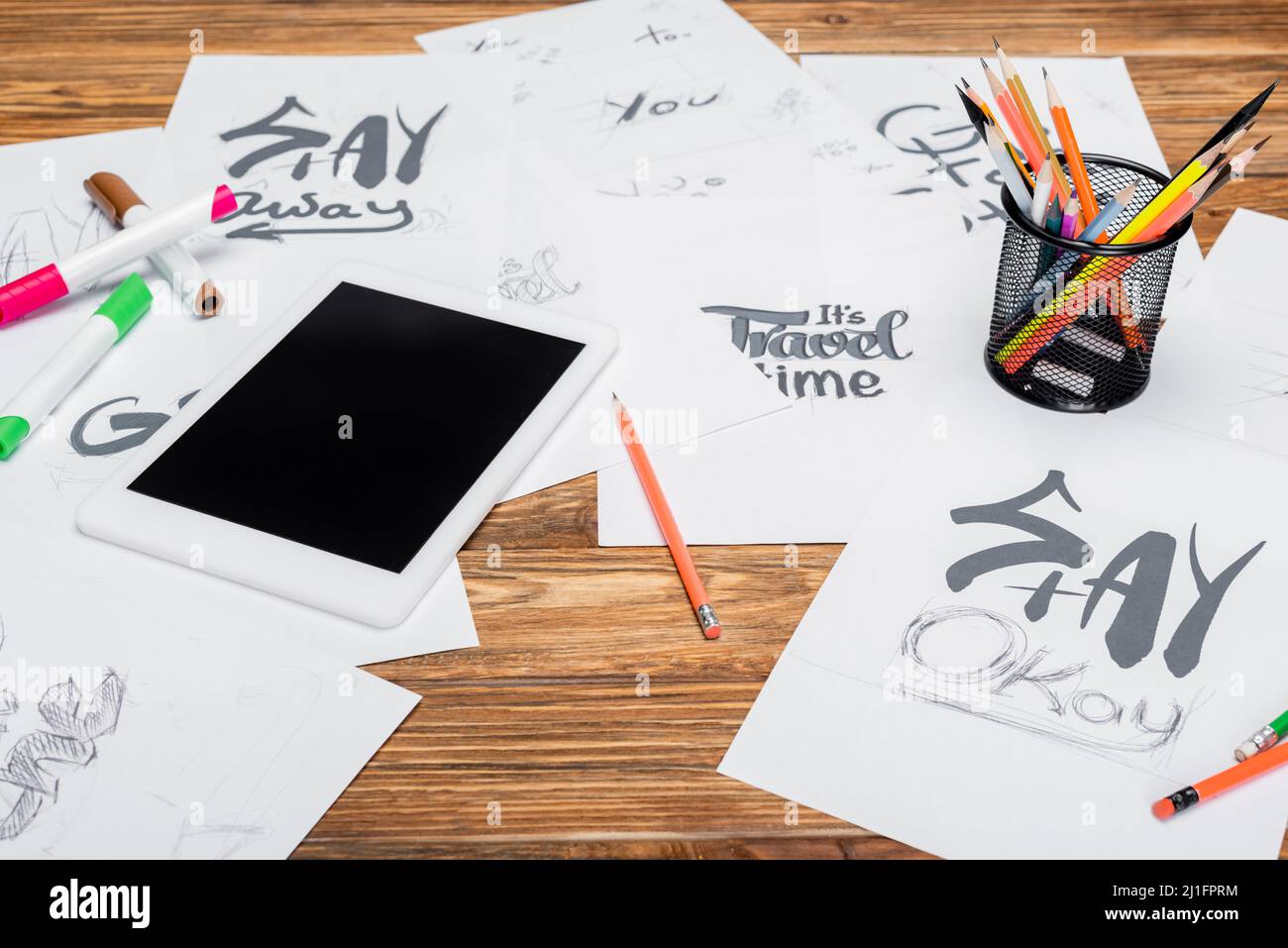 digital tablet with blank screen, color pencils and papers with ...