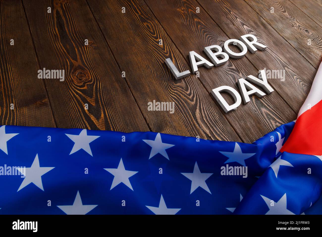 words labor day laid with silver metal letters on wooden surface with ...