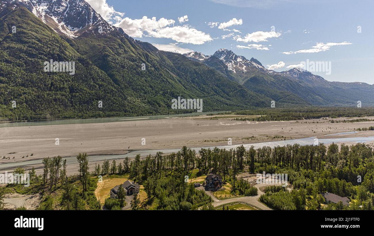 An aerial view of a summer day over the rural area near mountains in ...