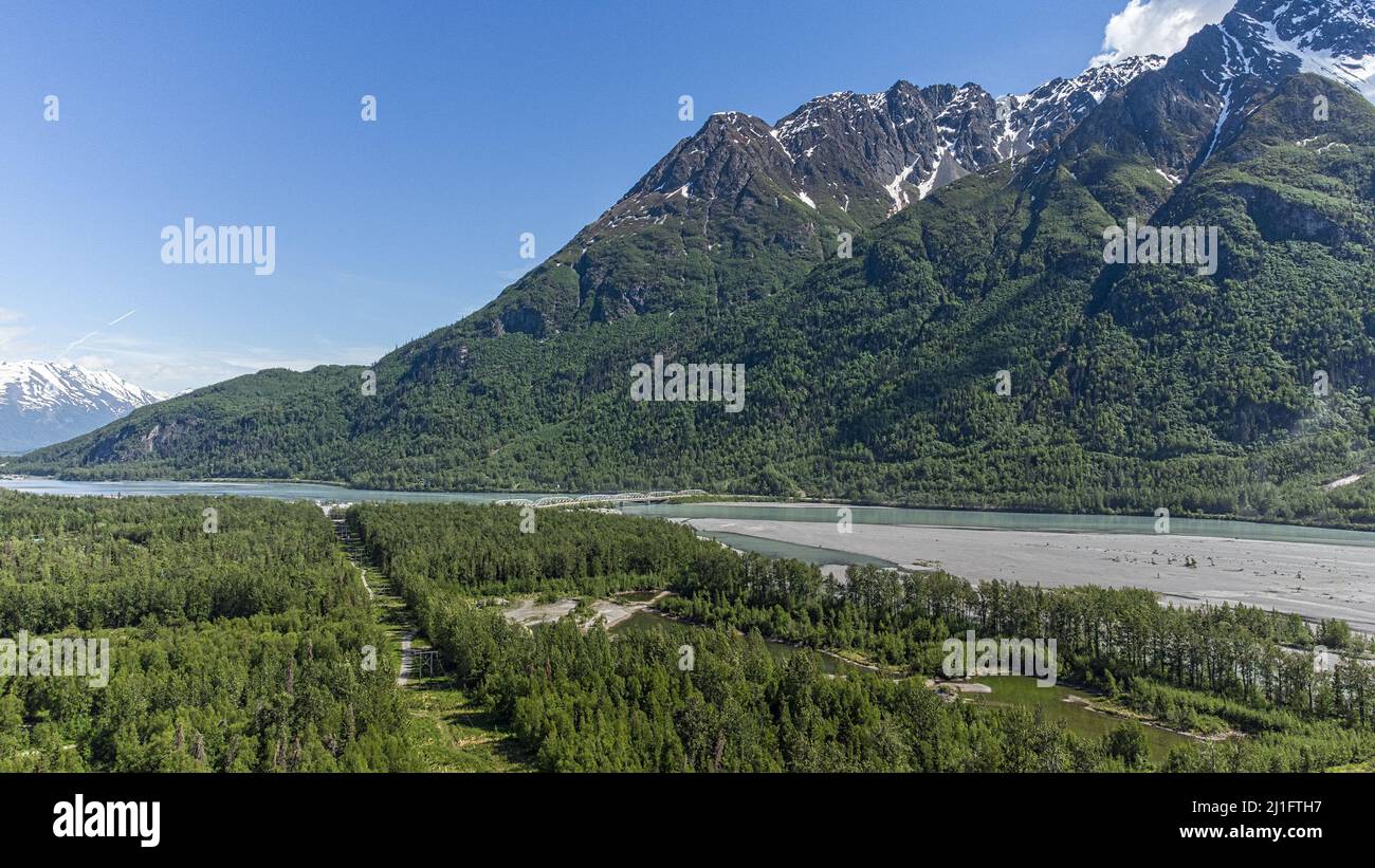 An aerial view of a summer day over the rural area near mountains in ...