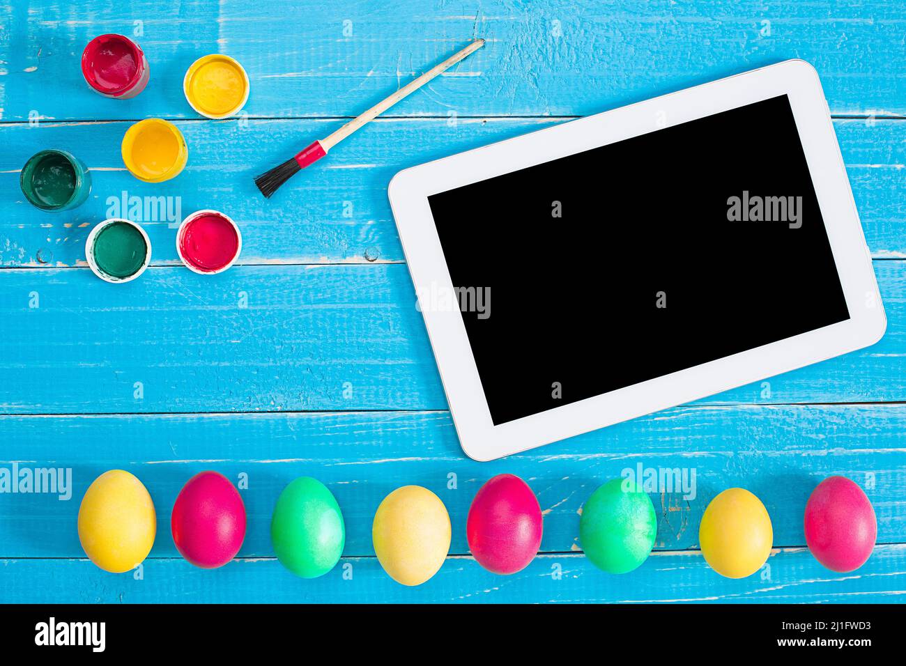 Colorful easter eggs, brush and paint on wooden board background with ...