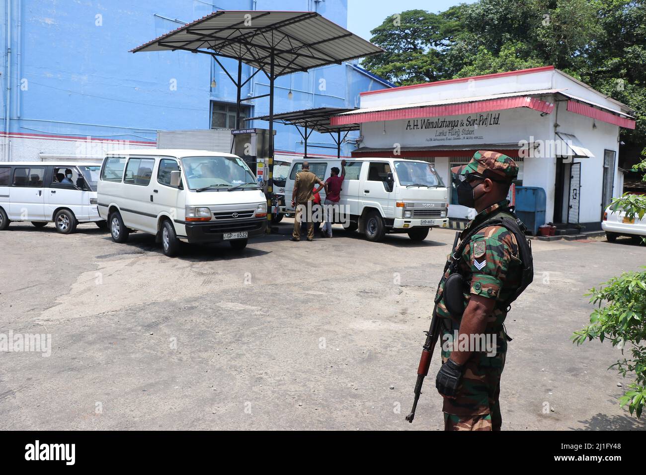 Sri Lankan army soldier guards a fuel station as people wait to get ...