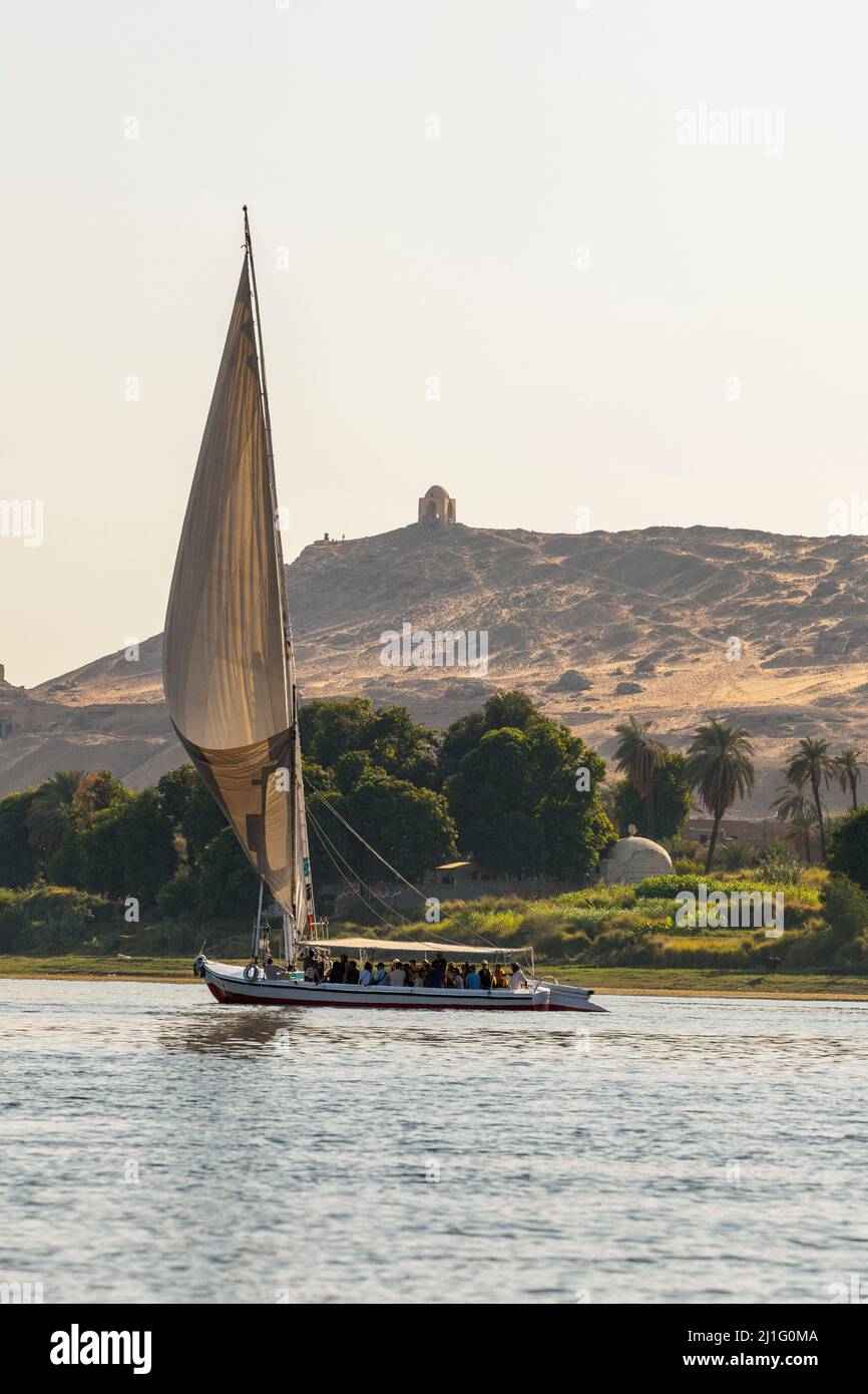 Felucca with Qubbet el-Hawa hilltop shrine on the west bank of the Nile ...