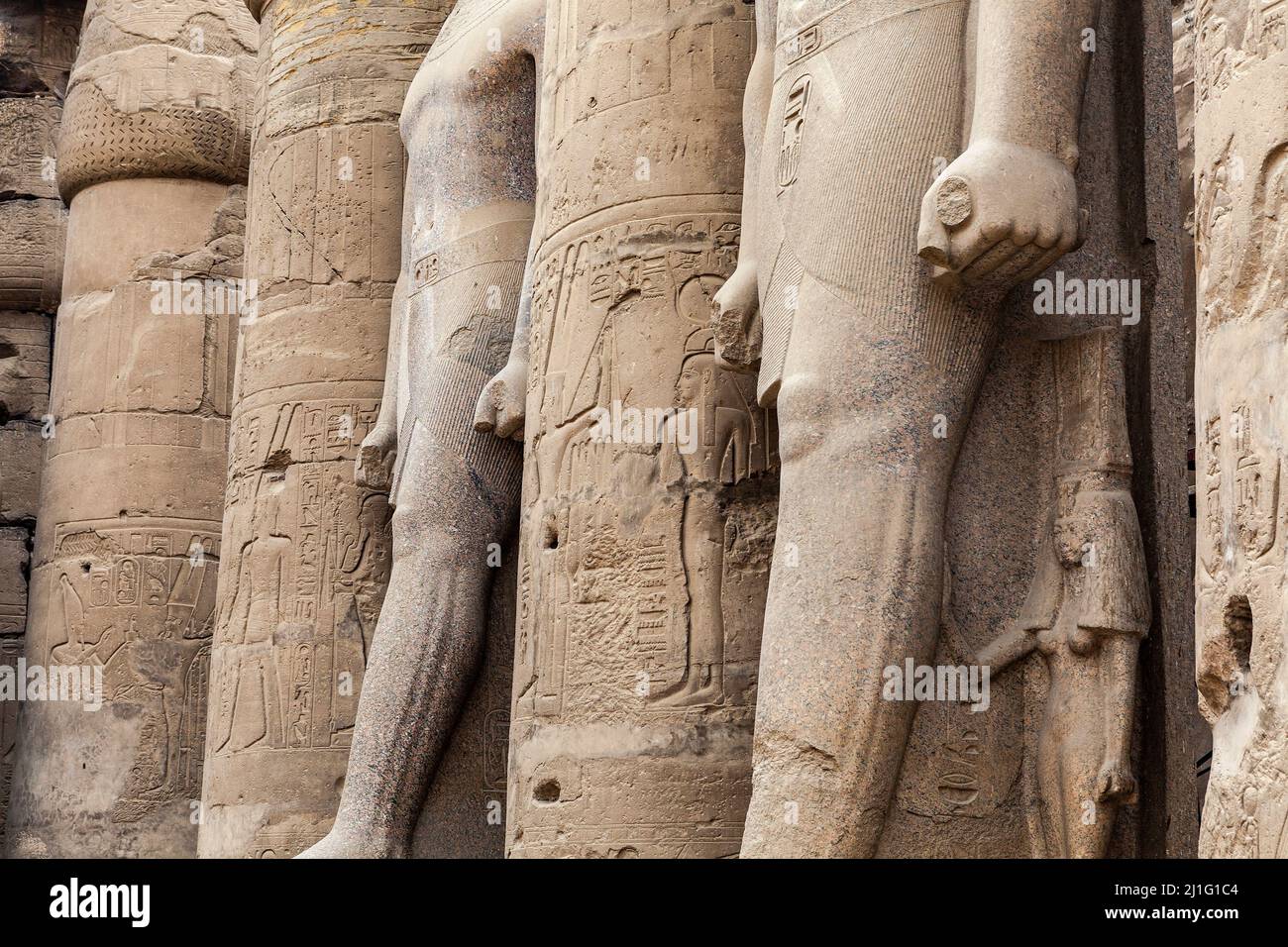 Legs of statues between columns of Courtyard of Rameses II, Luxor ...