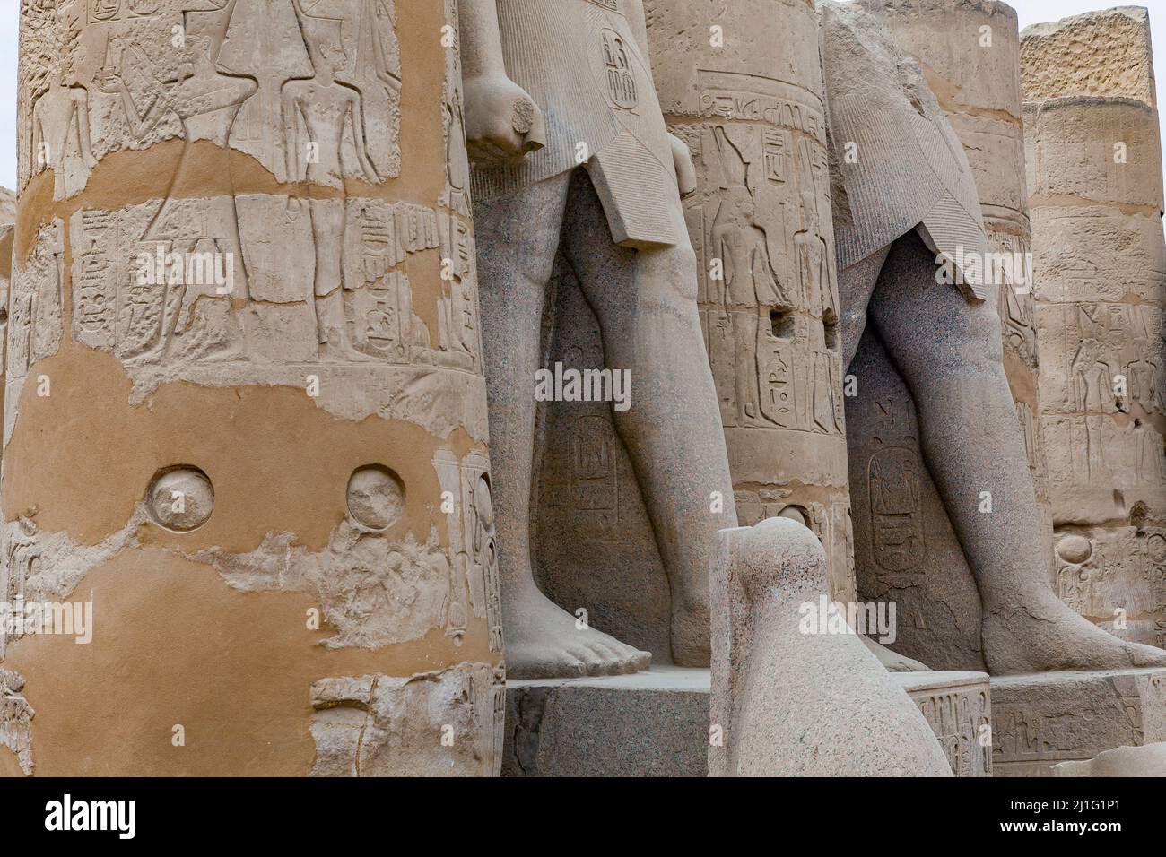 Legs of statues between columns of Courtyard of Rameses II, Luxor ...
