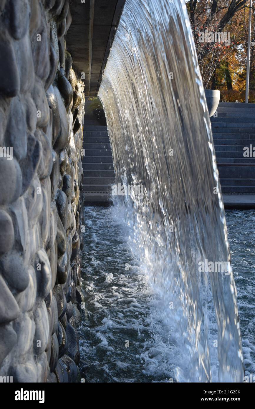 A waterfall flowing at park. A waterfall of a fountain in a garden ...