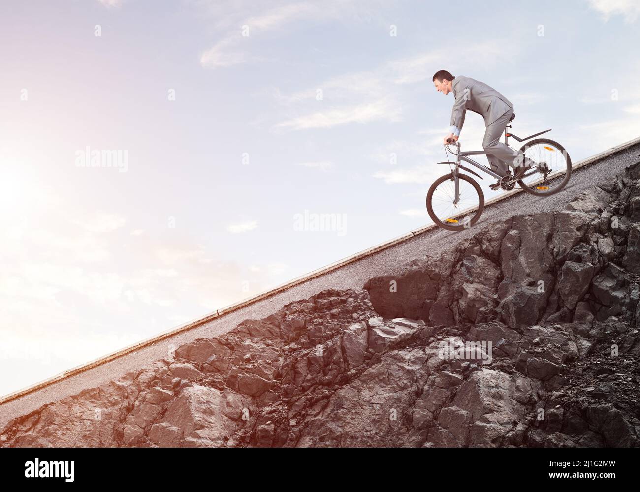 Businessman riding downhill by bike Stock Photo - Alamy
