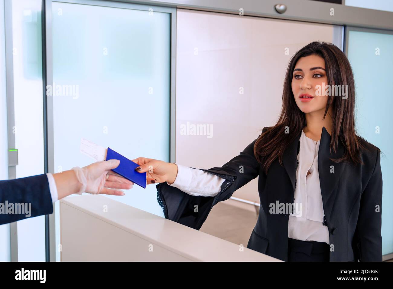 Beautiful girl on checking-in her tickets and receiving boarding pass ...