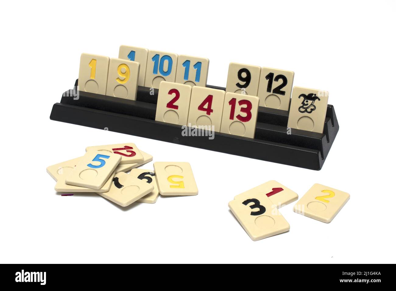 Close up of rummy game pieces with numbers and one joker partly stacked ...