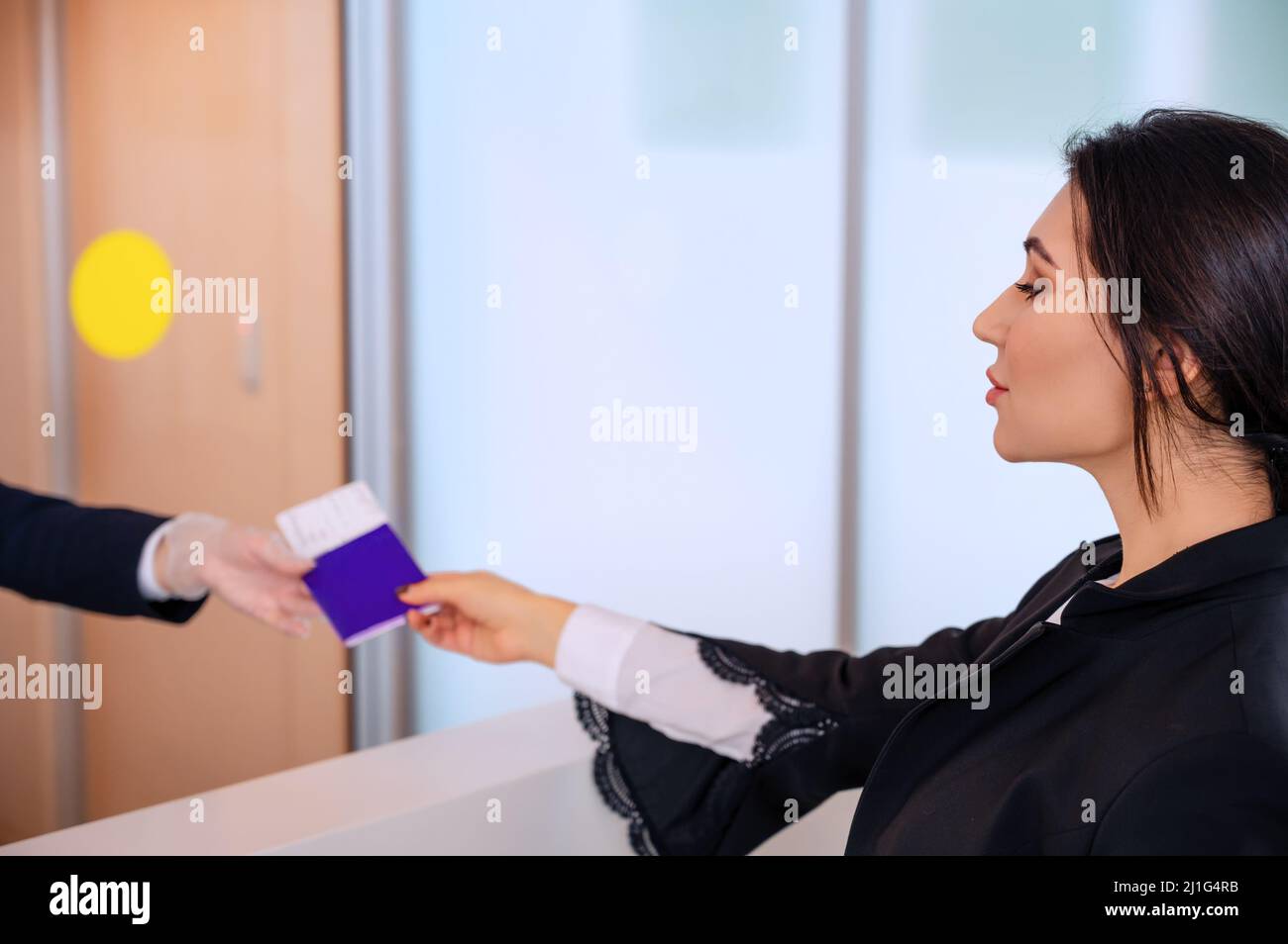 Beautiful girl on checking-in her tickets and receiving boarding pass ...