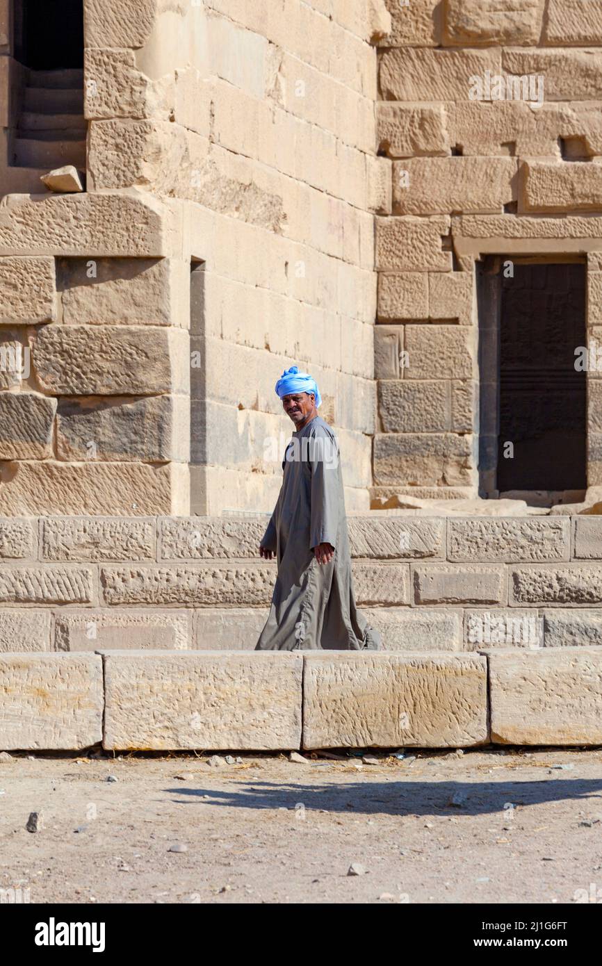 Local Egyptian walking in front of the first pylon of the Temple of ...